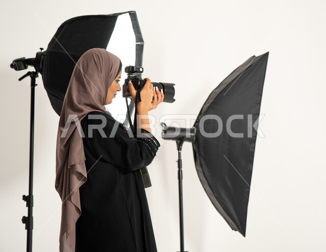 A Gulf Saudi Arab photographer holding the camera and taking ...
