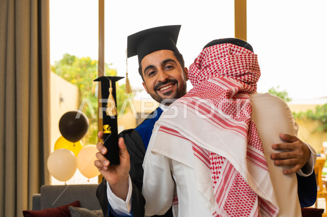 A university graduate wearing graduation clothes and holding a ...