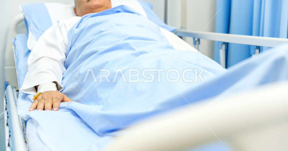 An old man, Arab, Gulf, Saudi, patient lying on a hospital bed ...