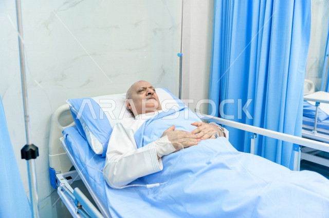 An old man, Arab, Gulf, Saudi, patient lying on a hospital bed ...