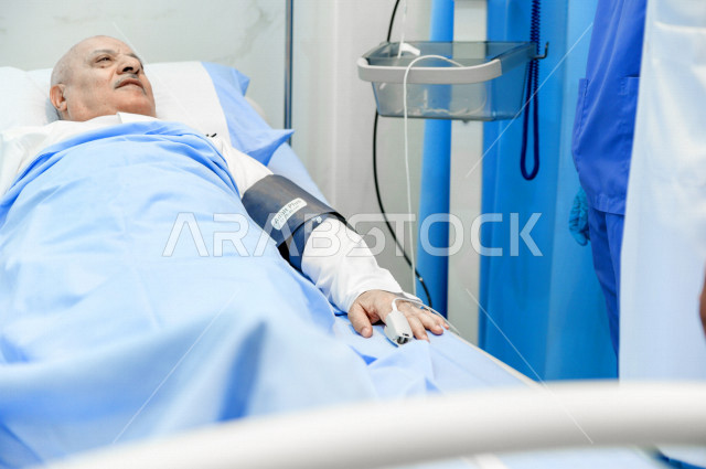 An old man, Arab, Gulf, Saudi, patient lying on a hospital bed ...