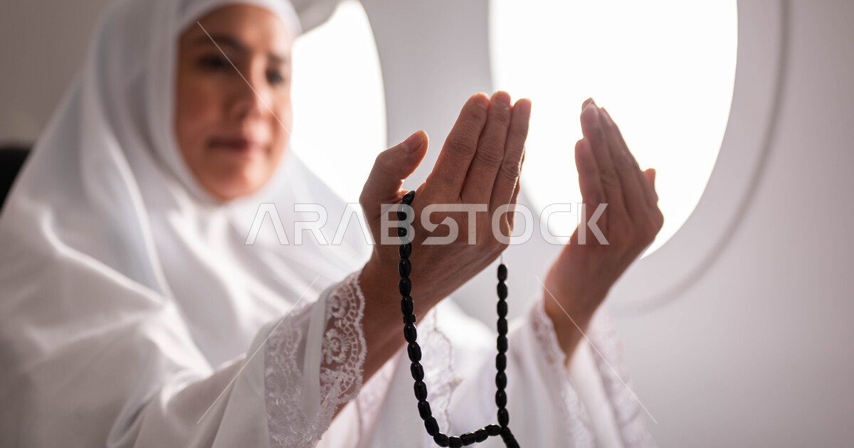 Wearing women's ihram clothes, an Indonesian Muslim woman holding a ...