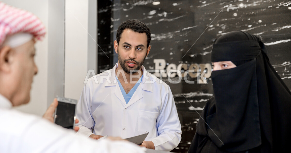 A Saudi Arabian Gulf man at the hospital reception, fills in his data ...