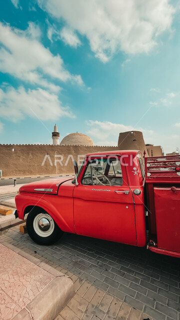 A close-up of a red Ford car in front of the historic Ibrahim Palace ...