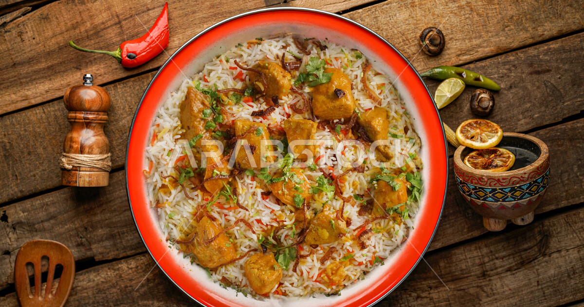 A dish of kabsa rice with chicken on a wooden base, dishes from popular ...