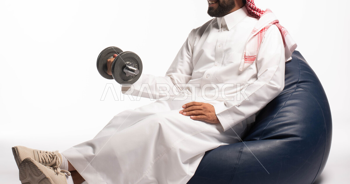 Bodybuilding, a portrait of a Saudi Arabian Gulf man sitting on a chair ...
