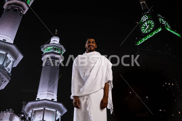 Standing in front of the Grand Mosque at night time, performing Umrah ...