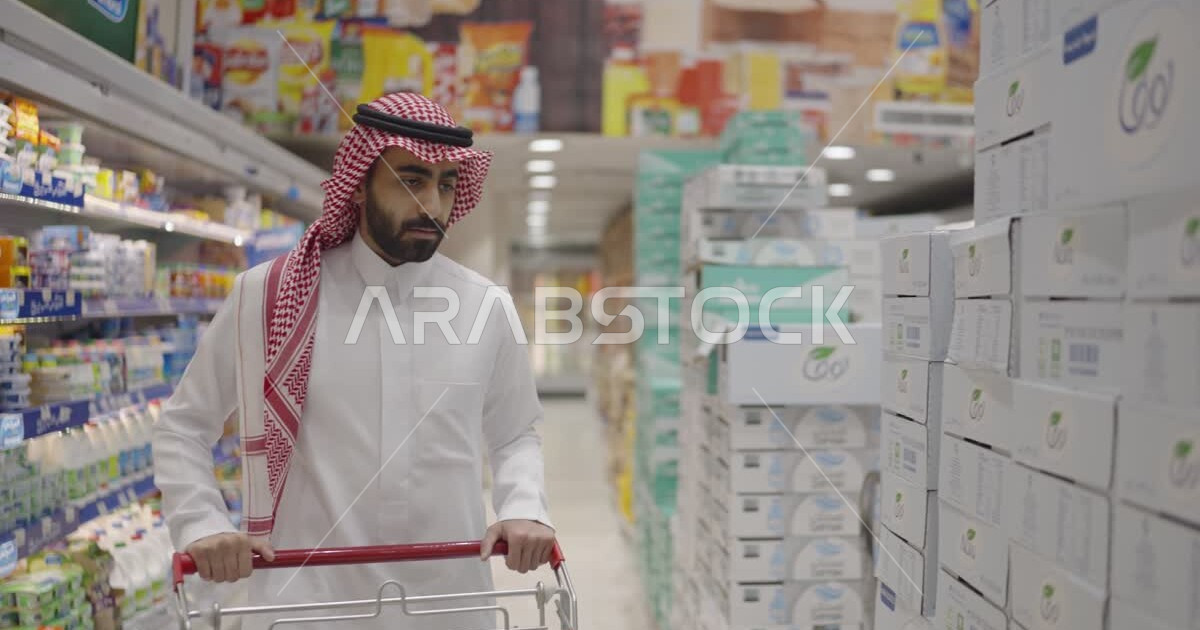 An Arab Gulf man shopping from the dairy section inside the supermarket ...