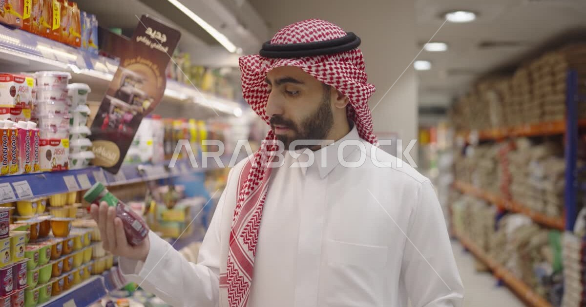 An Arab Gulf man shopping in the cold drinks section inside the ...