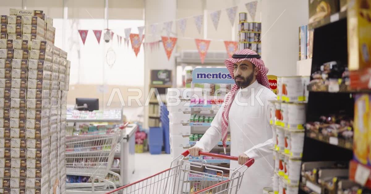 An Arab Gulf man shopping from the biscuits and chocolate section ...