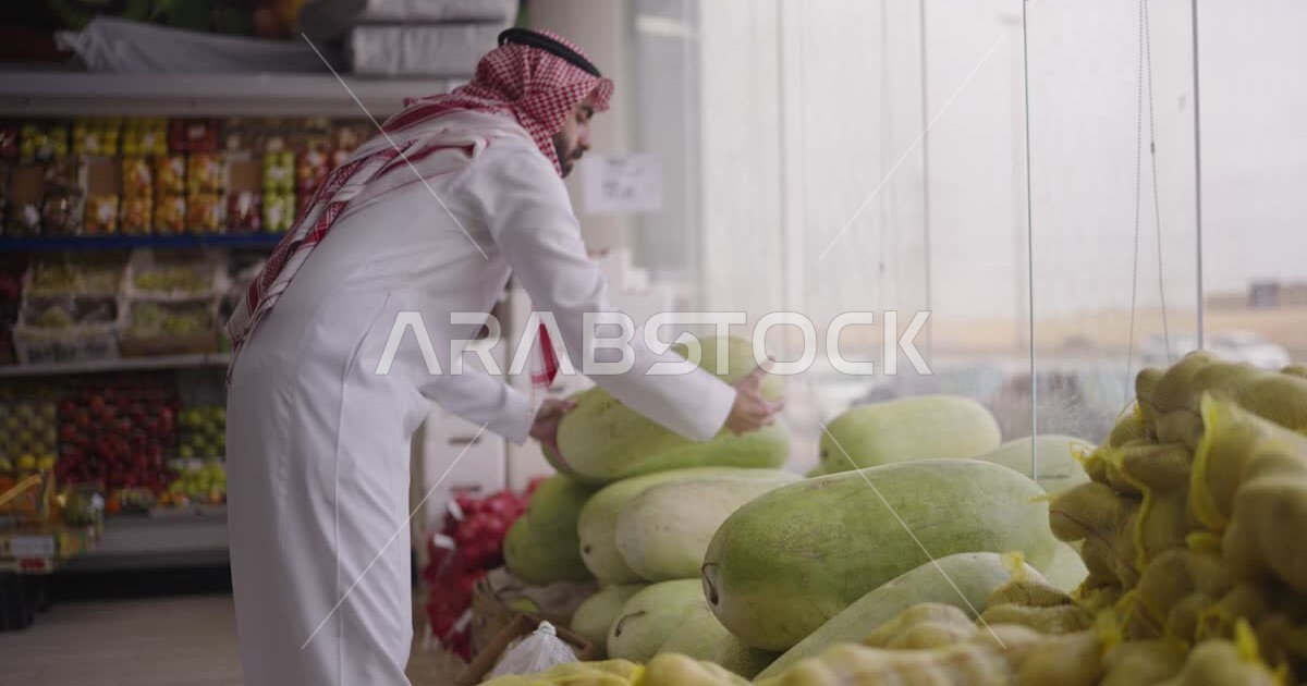 A Saudi Arabian Gulf man shopping green squash from the vegetable ...