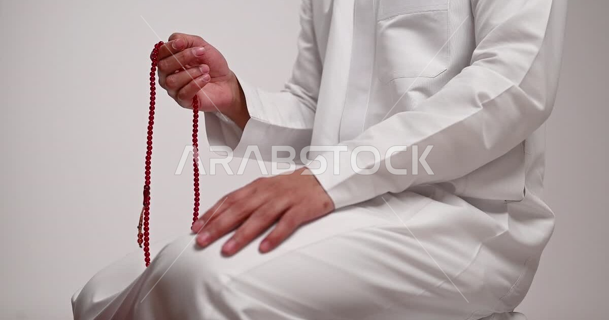 A close-up depiction of a Saudi Arabian Gulf man doing tasbih ...