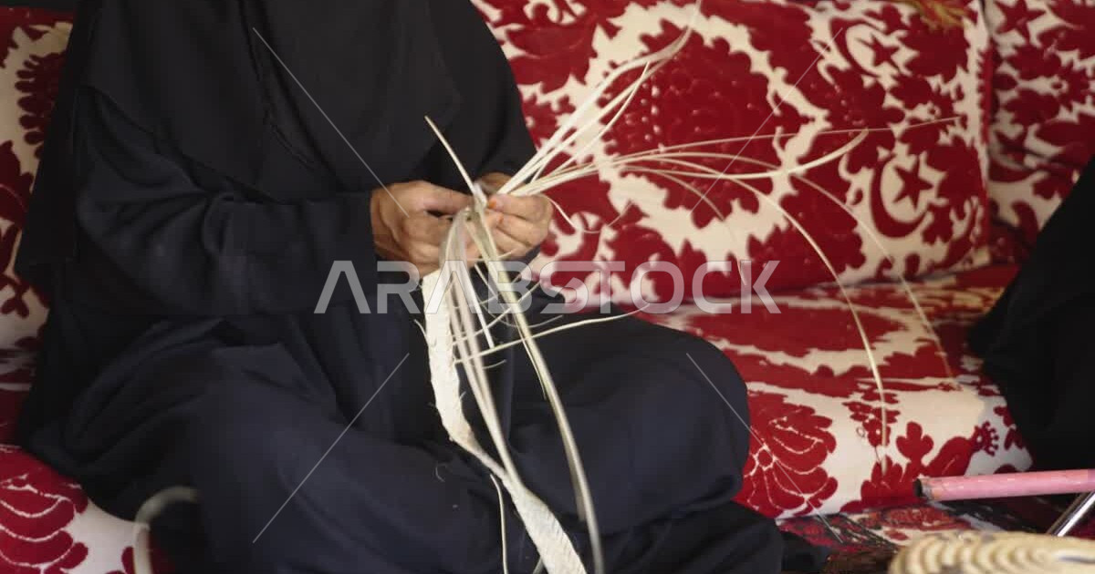 The craft of wicker making, a close-up of a veiled Saudi Arabian Gulf ...