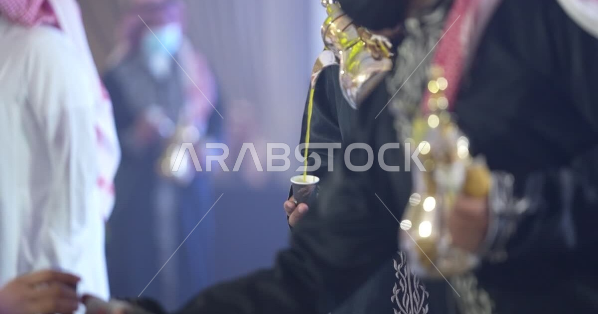 Serving hot coffee to the guests, a close-up of a Saudi Gulf man ...