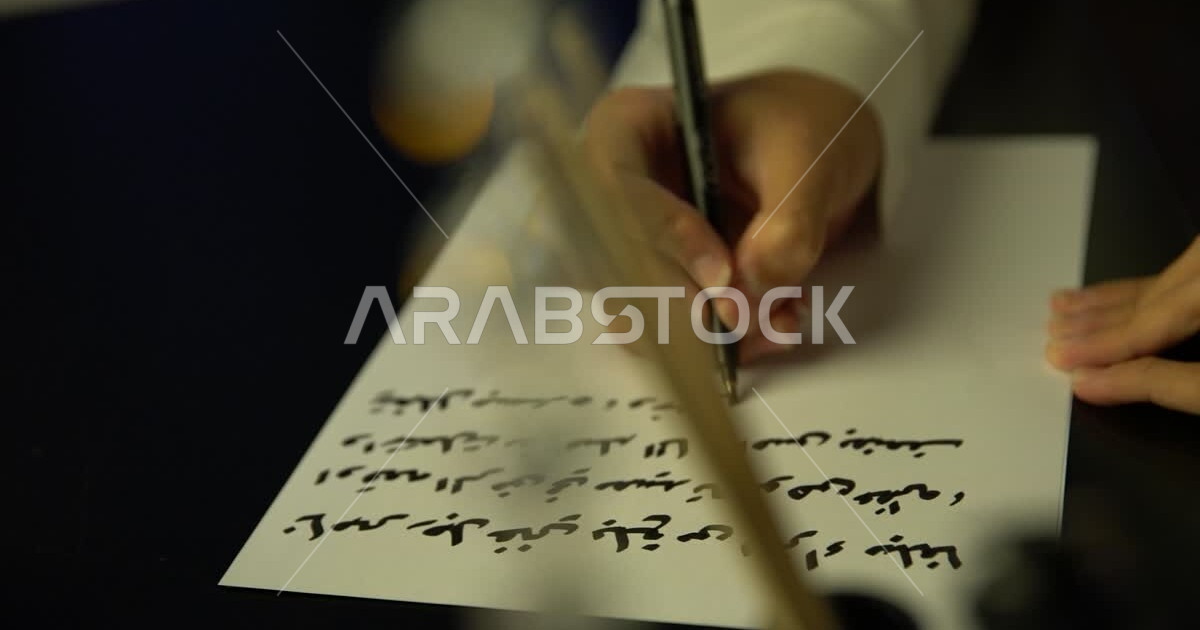 A close-up depiction of a Saudi Gulf Arab writer writing using paper ...