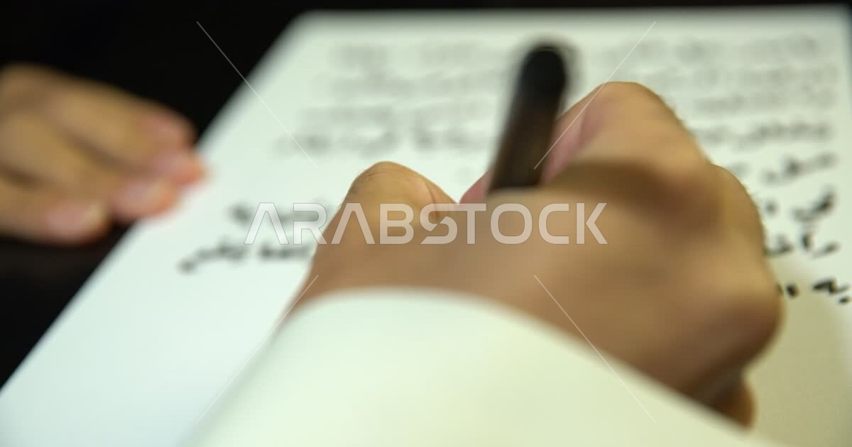 Writing and composing literary stories and novels, close-up of a Saudi ...