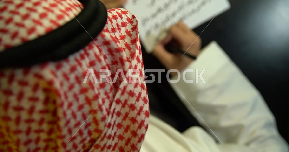Writing using paper and pen, close-up depiction of a Saudi Gulf Arab ...