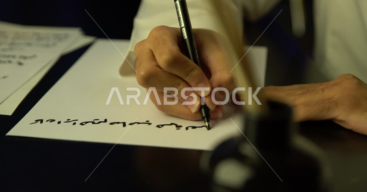 Writing using paper and pen, close-up depiction of a Saudi Gulf Arab ...