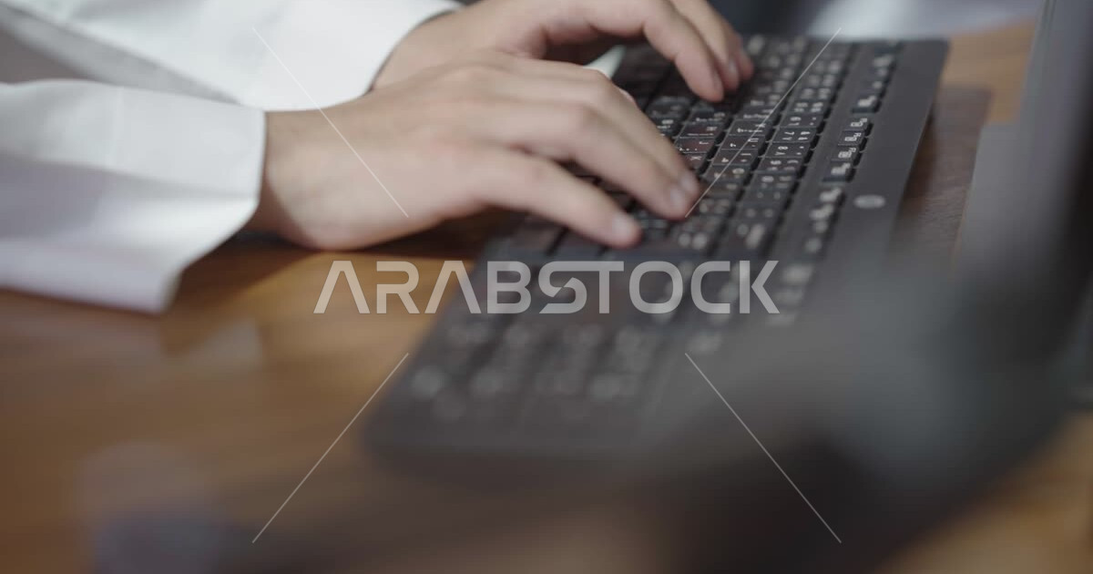 Close-up of an employee in the work office typing and writing on the ...