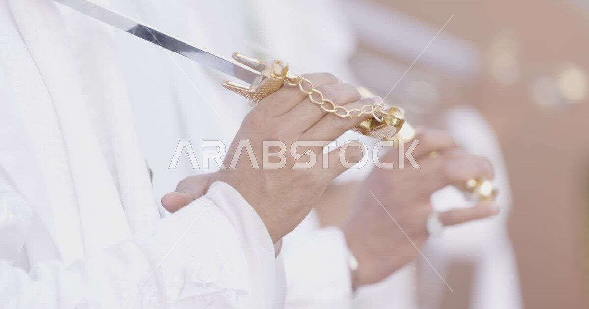 A group of men carrying swords, a Saudi Gulf Arda band, folk dances on ...