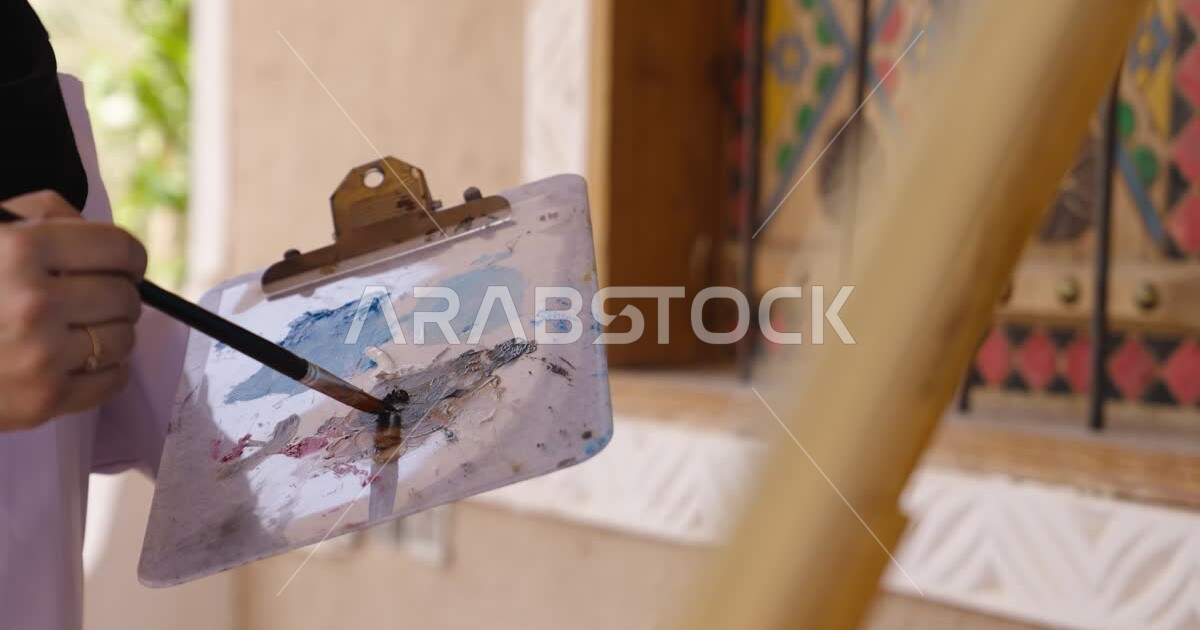 Close-up of a Saudi Arabian Gulf woman carrying drawing tools, an ...