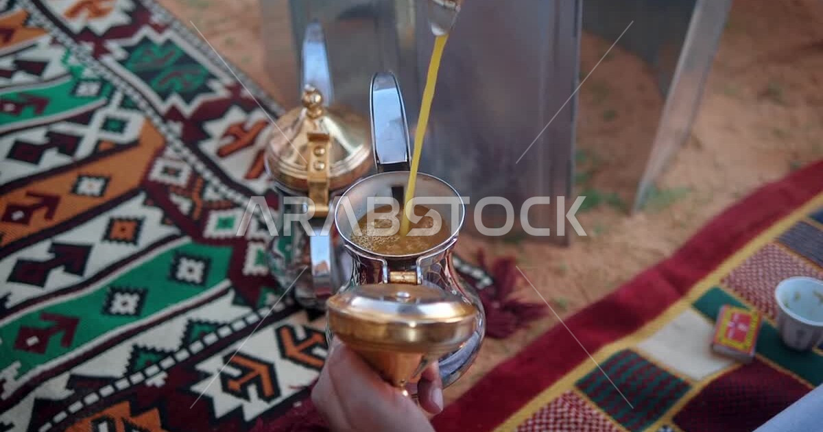 A close-up of a Saudi Arabian Gulf man pouring Arabic coffee, serving ...