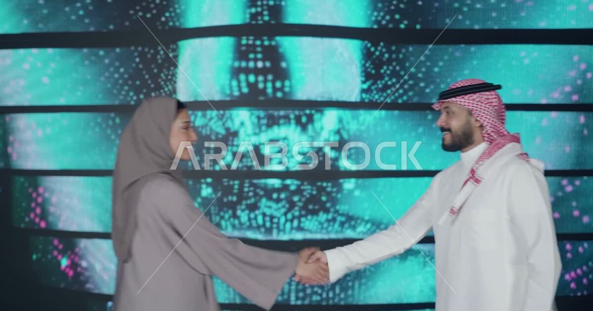 New work agreements, a Saudi Arabian Gulf man and woman shaking hands ...