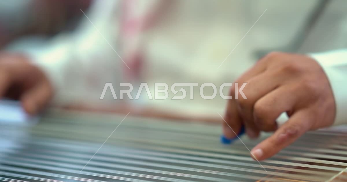 Playing the zither, a close-up of a Saudi Arabian Gulf man, an artist ...