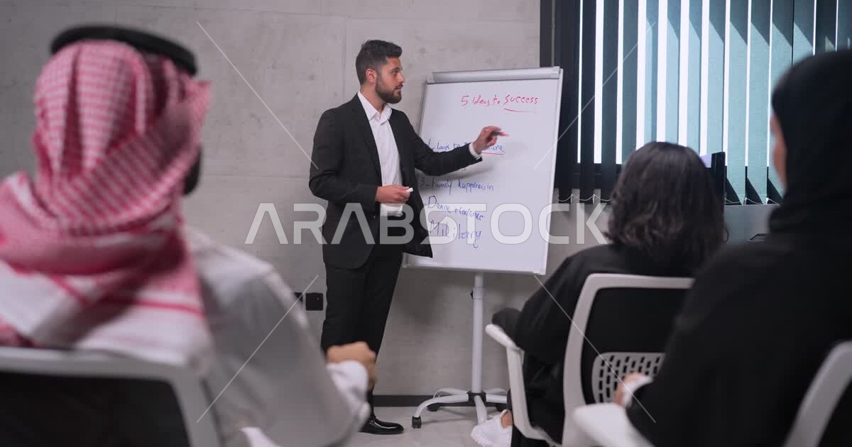 A meeting of Saudi Gulf Arab co-workers at the workplace, a businessman ...