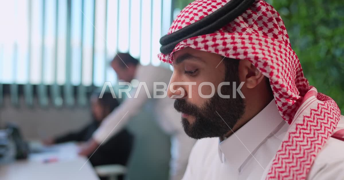 Using a laptop computer to accomplish daily work tasks, a Saudi Arabian ...
