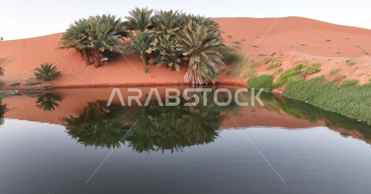 A small lake in the midst of soft golden sand dunes, hills and sandy ...