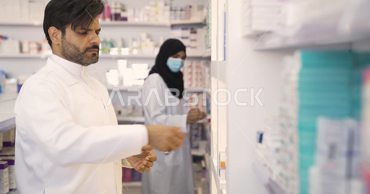 A man is a Saudi Arabian Gulf pharmacist holding medicine in his hand ...