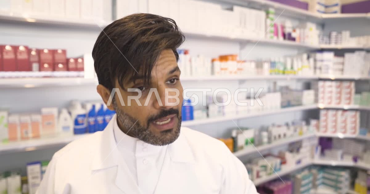 A Saudi Arabian Gulf pharmacist working in the pharmacy, giving ...