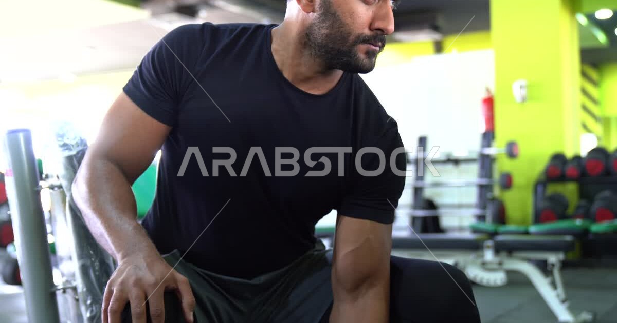 A young Saudi Arabian Gulf man is practicing weightlifting in the club ...