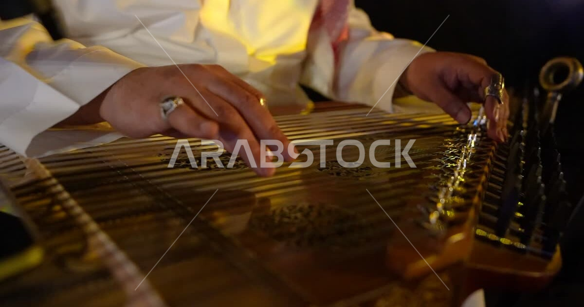 Practicing Saudi folk arts, playing the qanun, a close-up of a Saudi ...