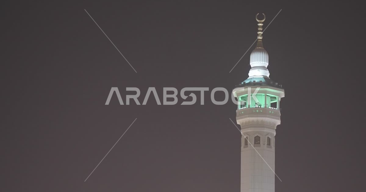 A close-up of the illuminated minaret of the Grand Mosque at night in ...