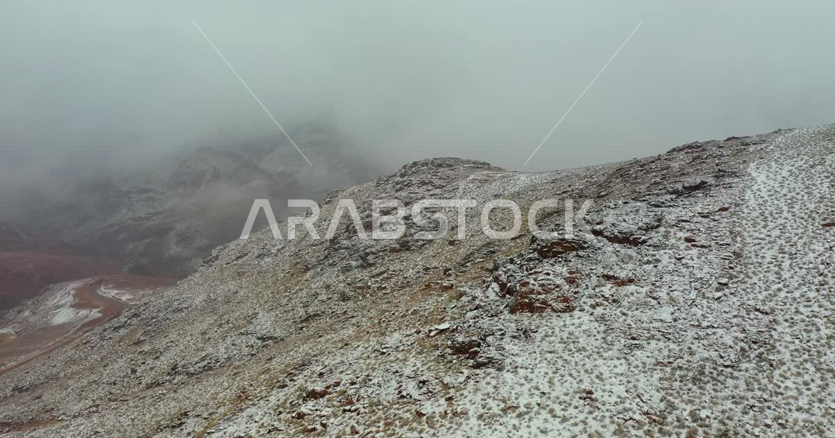 Overhead close-up of the fog over the snow-capped mountain ranges of ...