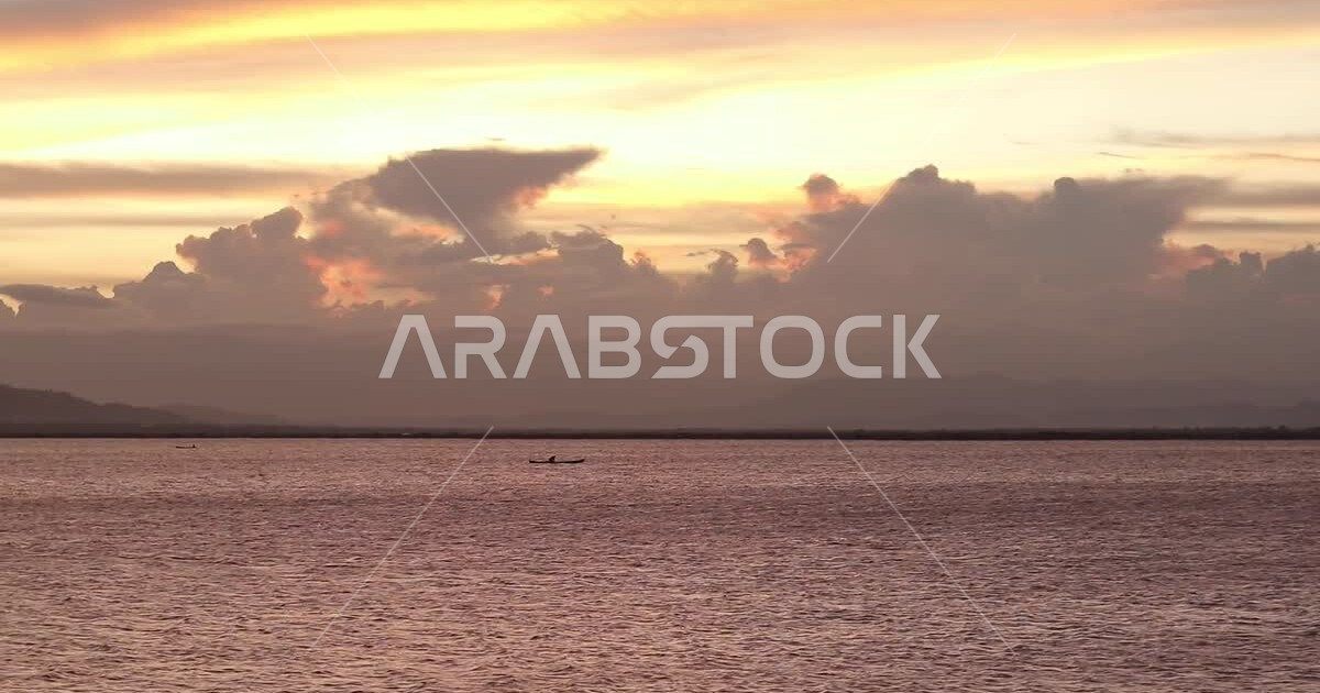 Sunset behind rainy black clouds in the sky, time-lapse of sea waves in ...