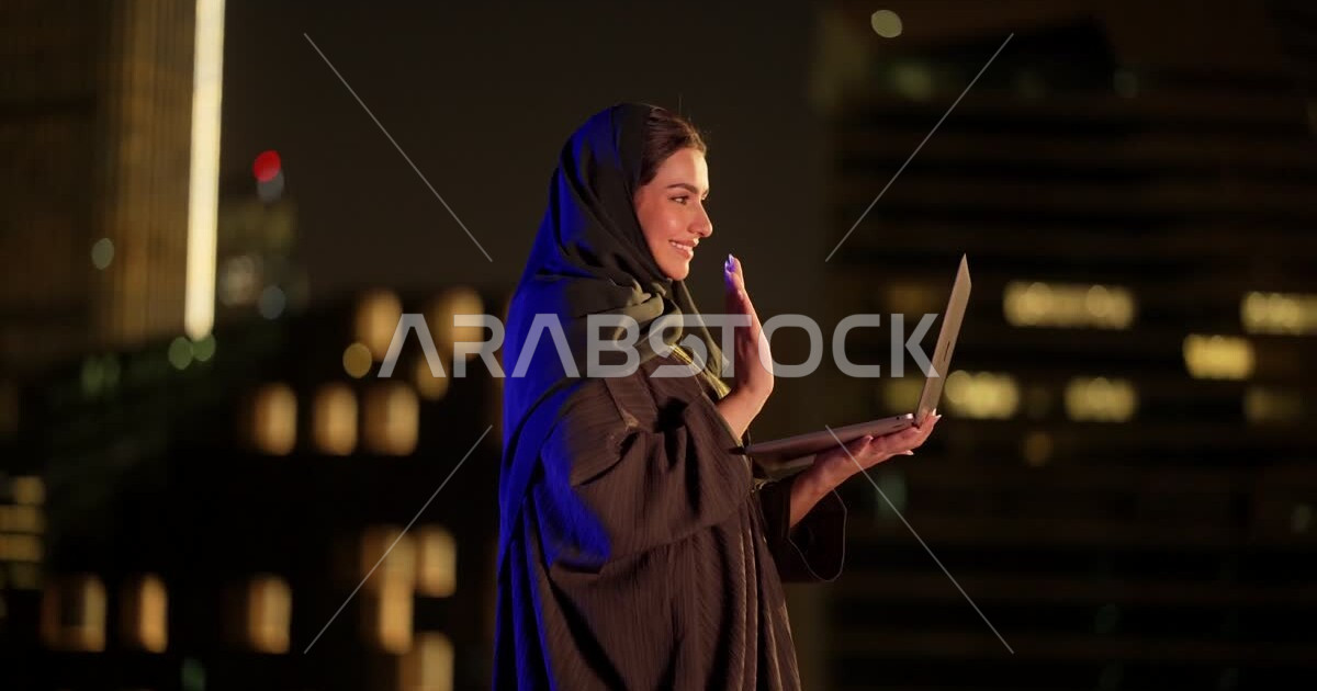 Making a video call via a computer, a Saudi Arabian Gulf woman wearing ...