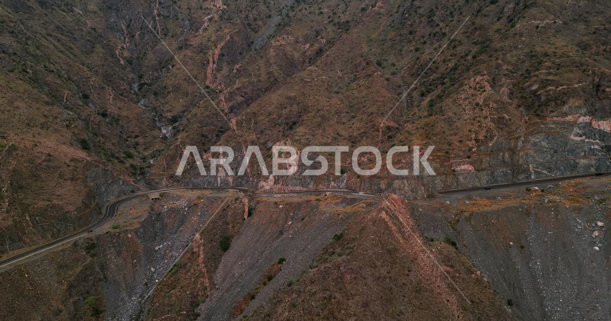 Asphalt road in the peaks and heights of the Al Shafa Mountains, drone ...