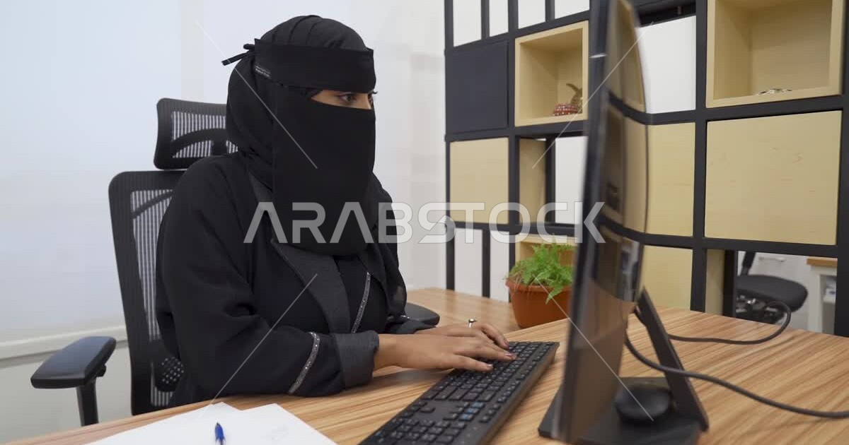 سيدة اعمال عربية سعودية خليجية ترتدي النقاب ، تعمل في المكتب و تستخدم