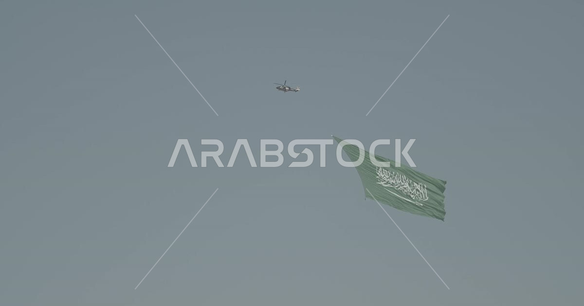 The flag of the Kingdom of Saudi Arabia flutters in the sky in ...