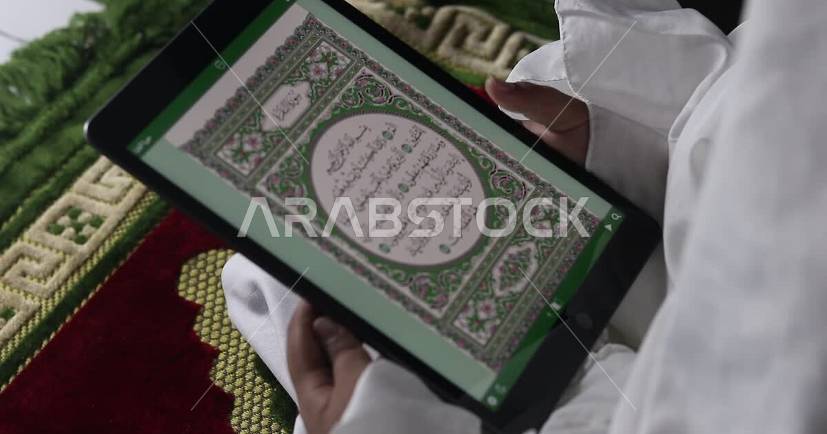 Close-up of a young Saudi Arabian Gulf girl sitting on a prayer mat and ...
