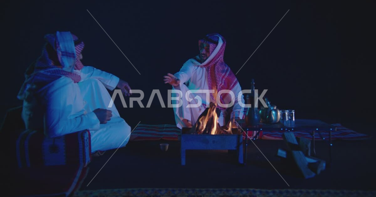 Arabic coffee dallah, two young Saudi Gulf Arab men enjoying spending ...