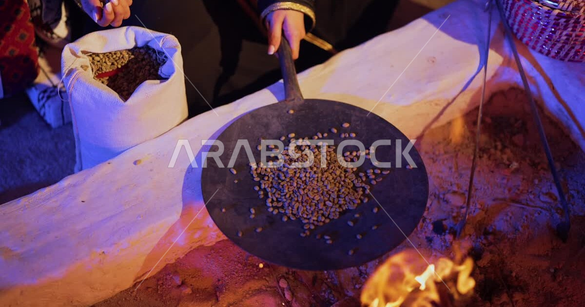 Putting coffee beans in the roaster to roast them over the flame of a ...