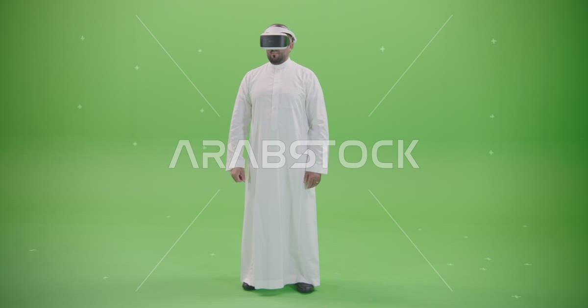 Simulating a virtual world, a Saudi Gulf Arab man wearing 3D VR glasses ...