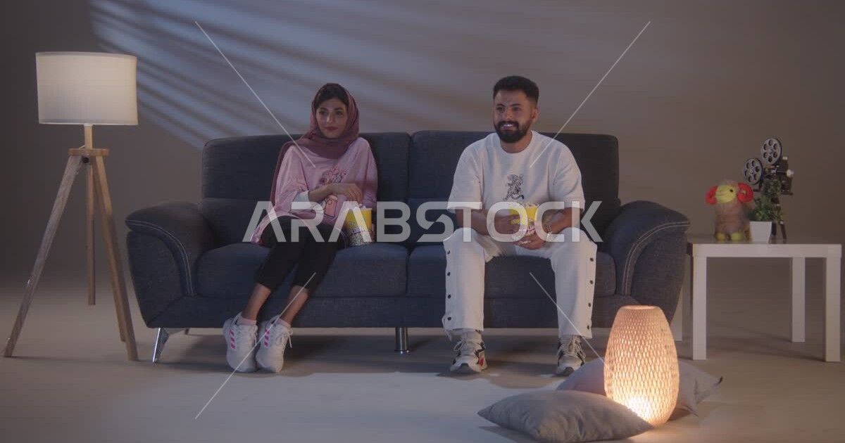 قضاء اوقات ممتعة في مشاهدة الافلام والبرامج التلفزيونية، زوجان عربيان