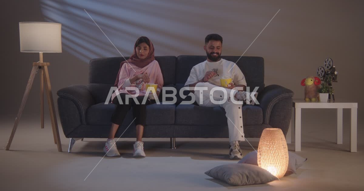 ايماءات وجه تدل على السعادة، زوجان عربيان خليجيان سعوديان يجلسان على