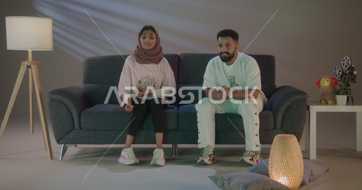 شابة بإيماءات وجه ويدين تدل على الفوز والانتصار، زوجان عربيان خليجيان