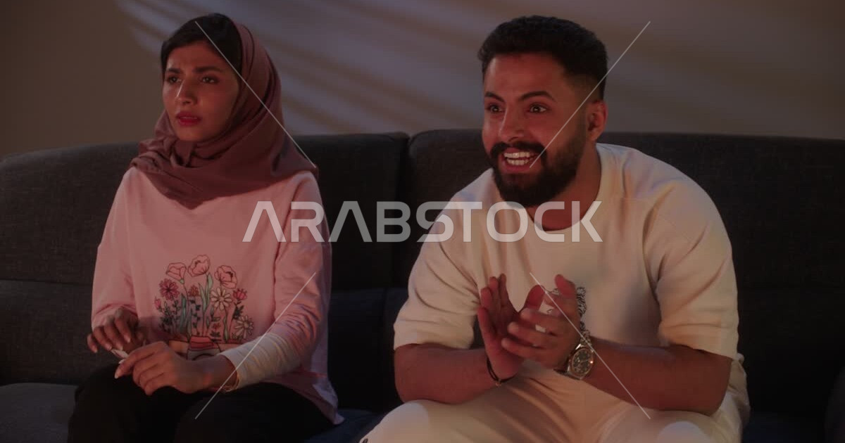 مفهوم الفوز والخسارة، زوجان عربيان خليجيان سعوديان يجلسان في غرفة